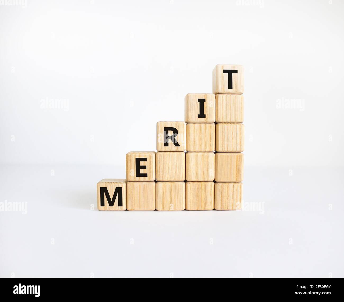 Merit symbol. Wooden cubes with word 'merit' stacking as step stair on ...