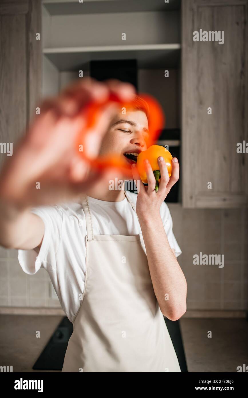 chef guy preparing vegan salad, fresh pepper, in the kitchen. healthy ...