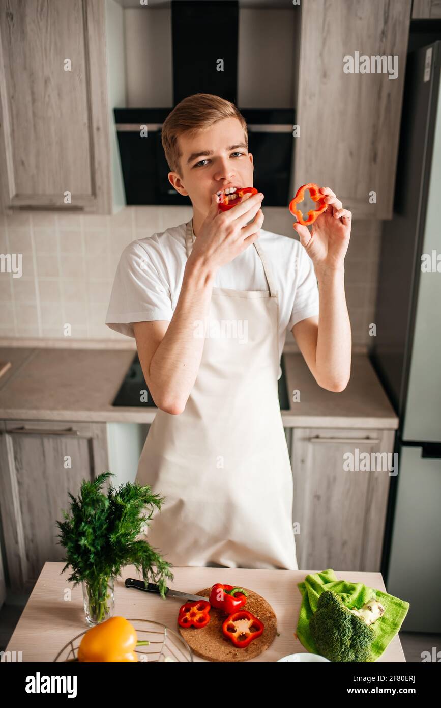 chef guy preparing vegan salad, fresh pepper, in the kitchen. healthy ...