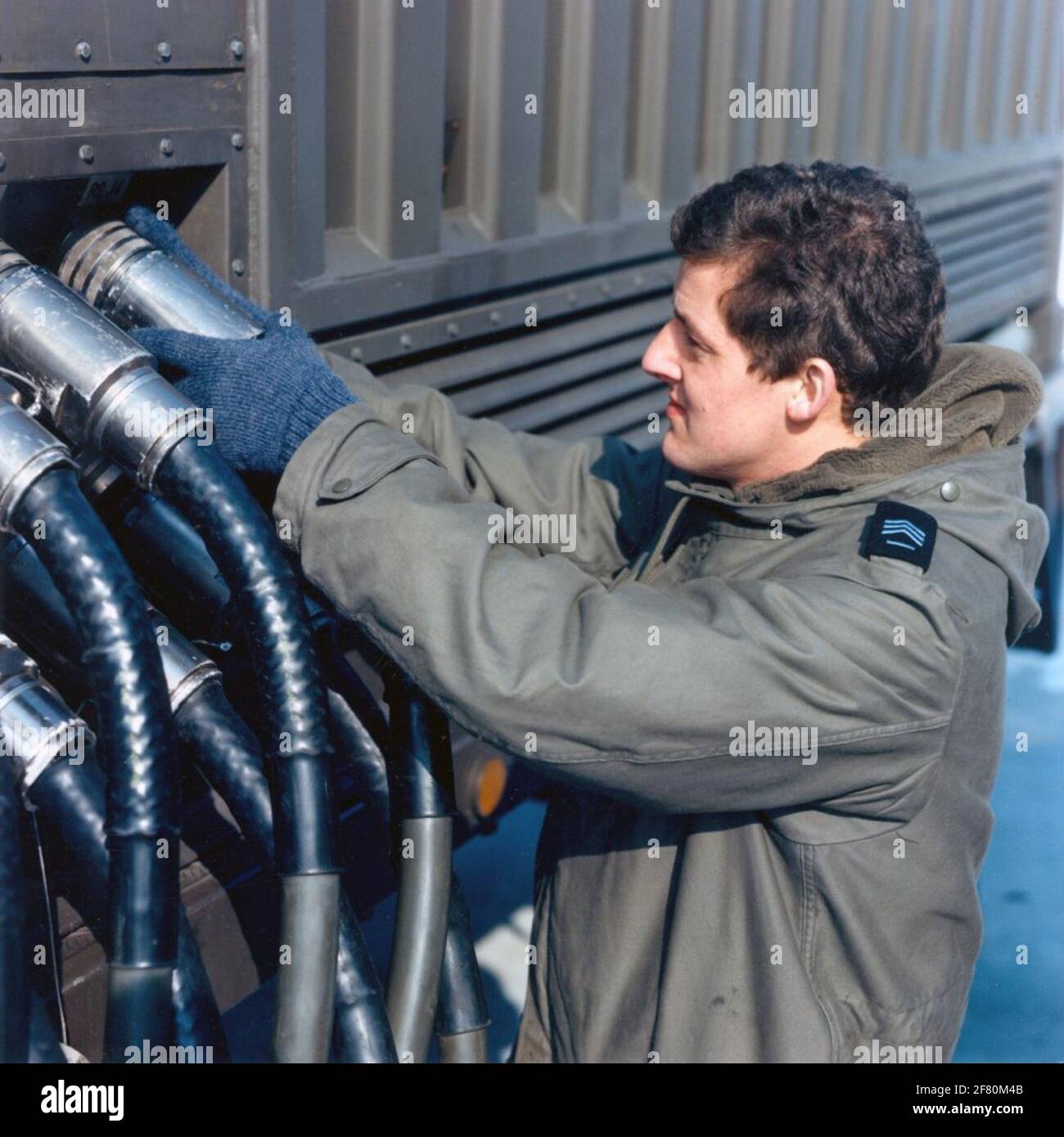 A sergeant of the first class confirms a heavy power cable to the ...
