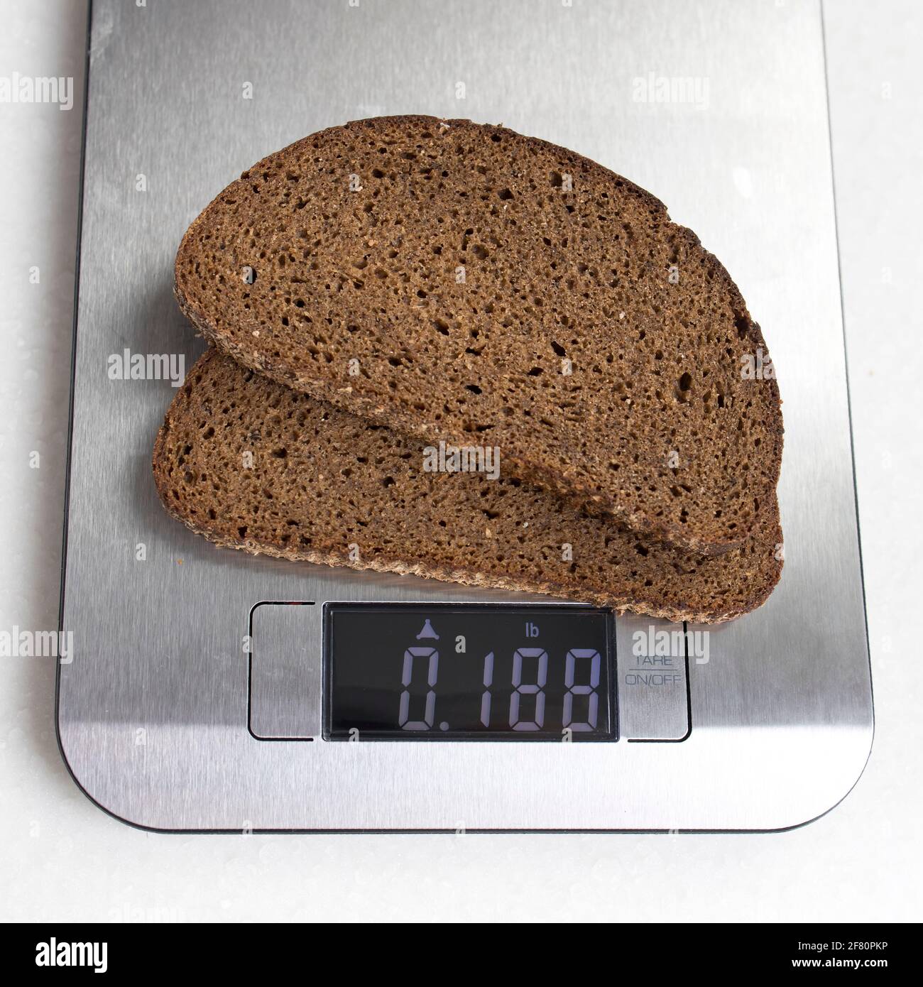 Two pieces of rye bread are weighed on a kitchen scale. Diet Stock ...