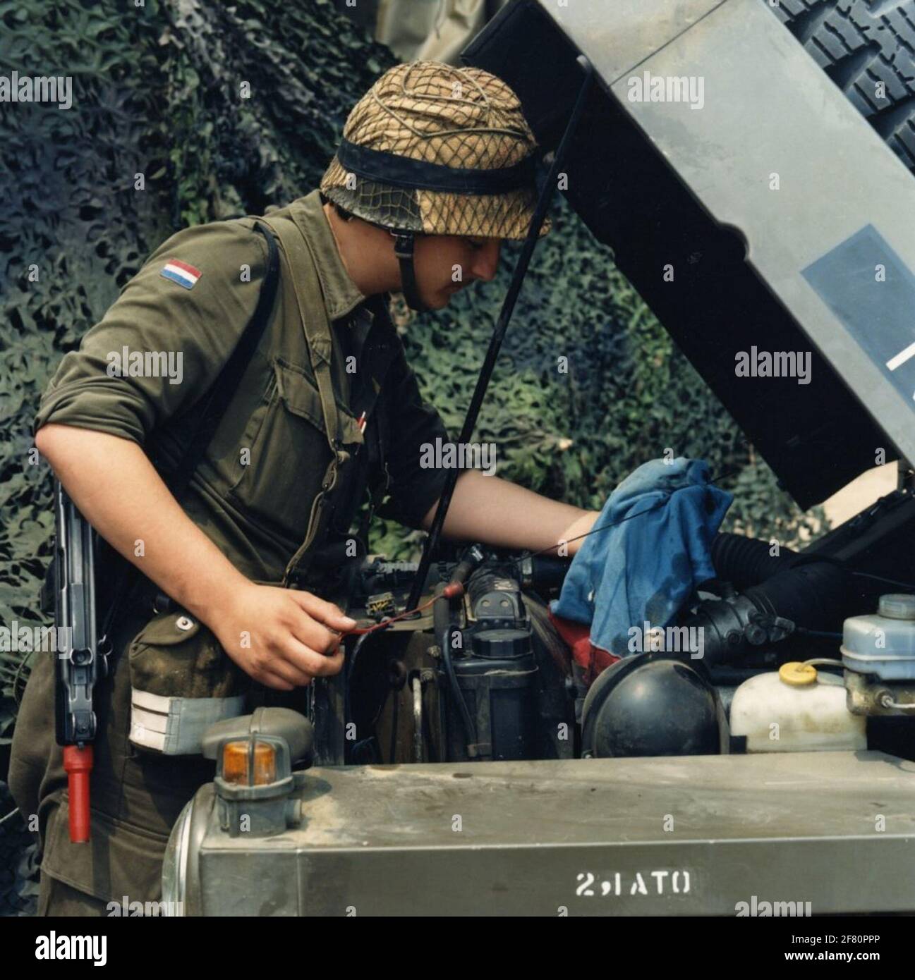 Soldier in combat suspension with dipstick and cleaning stand standing ...