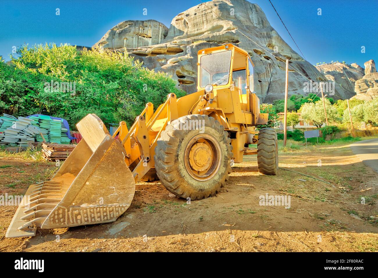 Side view of yellow excavator for building work along road in a ...