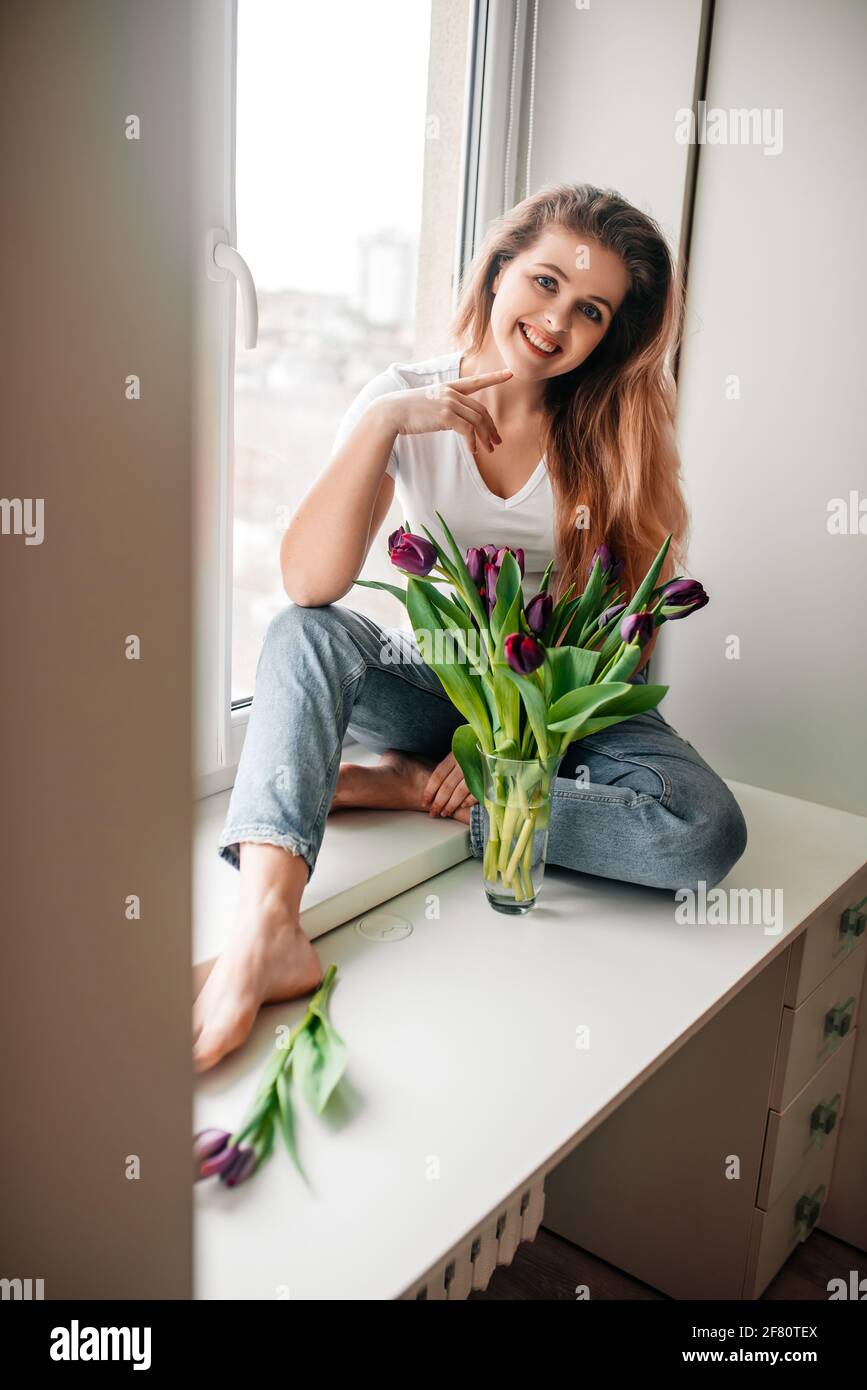 Lovable female girl in weekend morning. bouquet of tulips Stock Photo ...