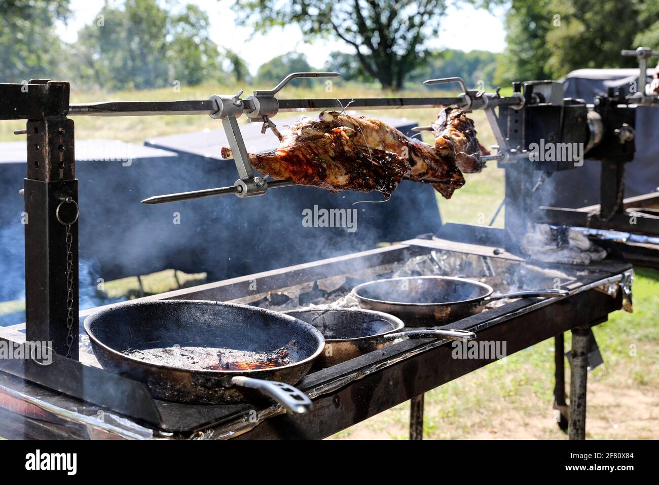 piece of meat cooking outdoor on a rolling stick Stock Photo - Alamy