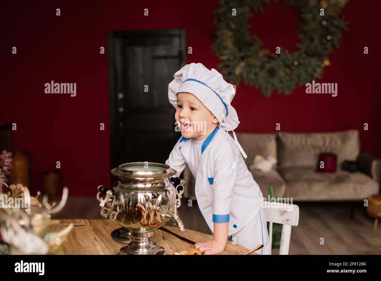 Portrait of a little boy cook holding pan at the kitchen. Different ...
