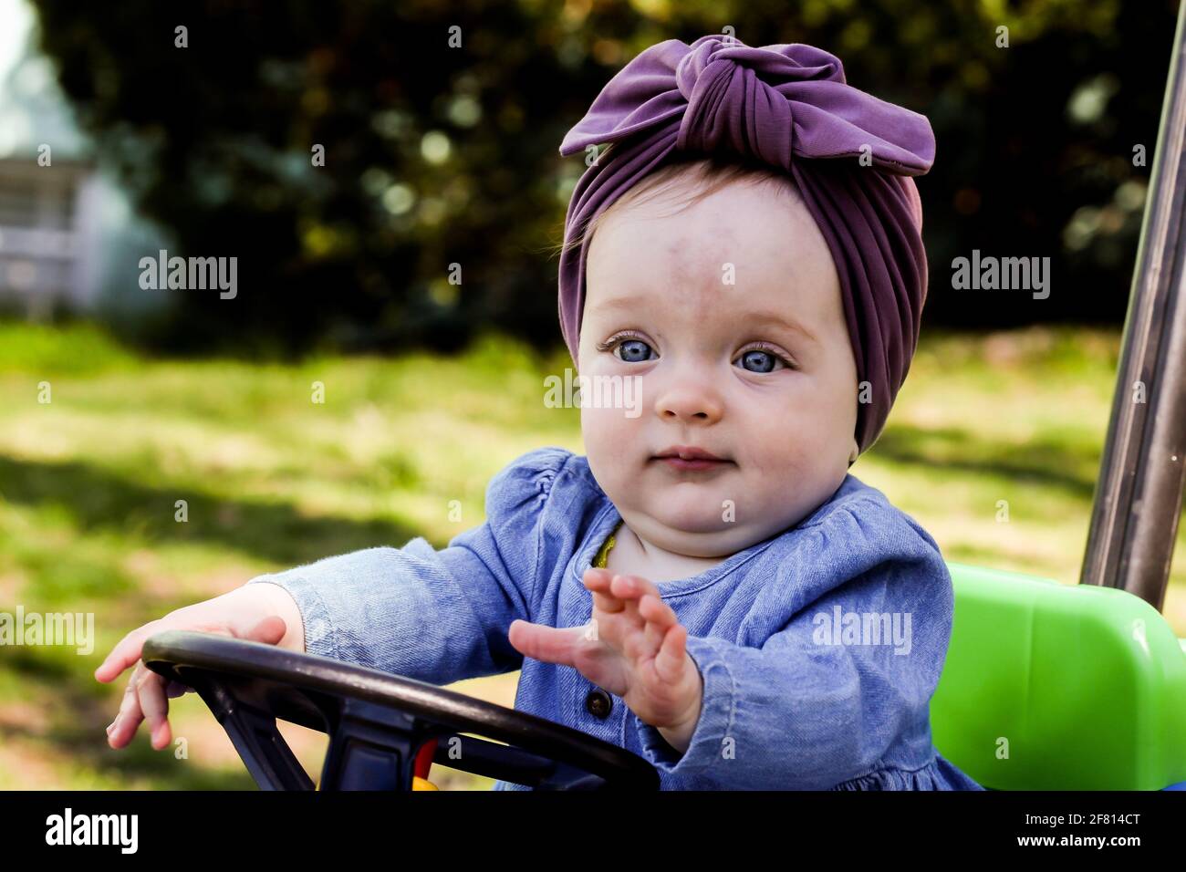 Cute baby girl outdoor in spring time holding toy car wheel Stock Photo ...