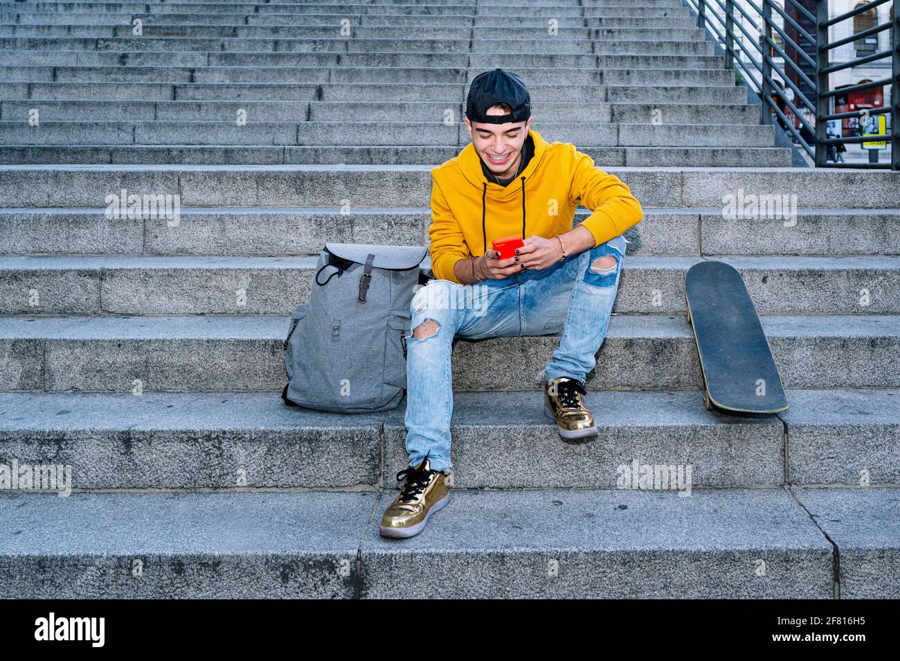 Profile of a happy boy using a smart phone on the street Stock Photo ...