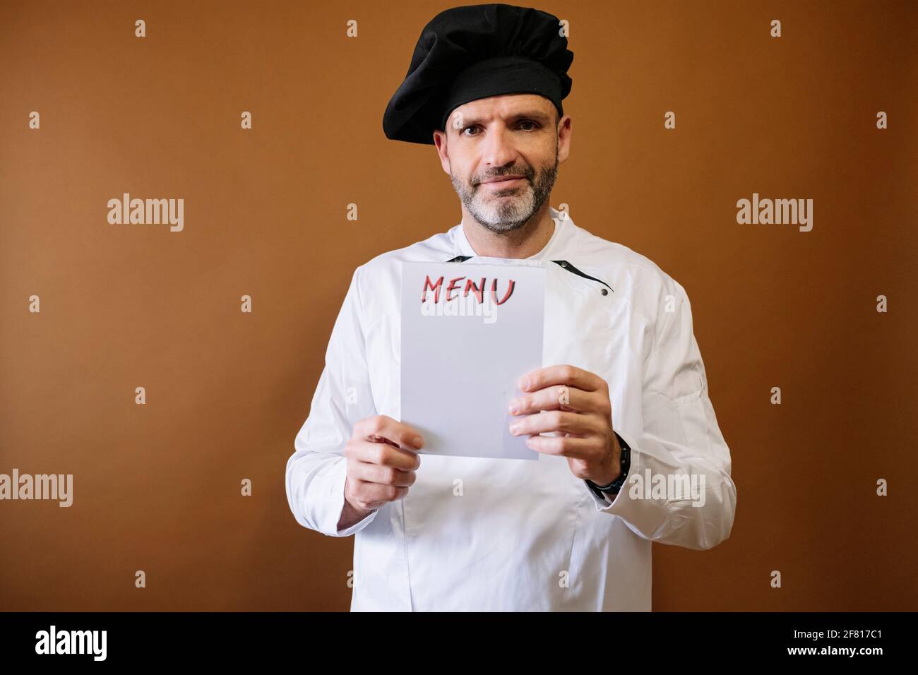 Chef man holding a sign that says menu Stock Photo - Alamy