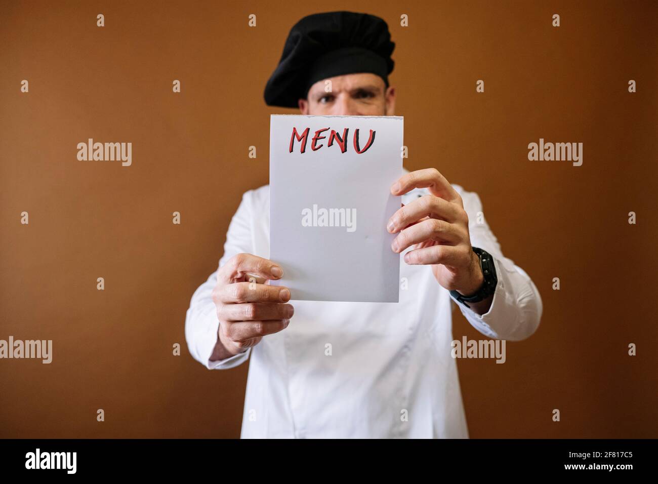 Chef man holding a sign that says menu Stock Photo - Alamy