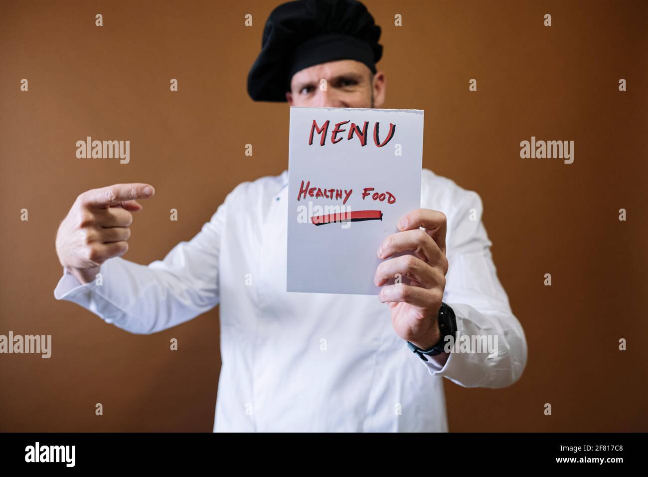 Chef man holding a sign that says menu Stock Photo - Alamy