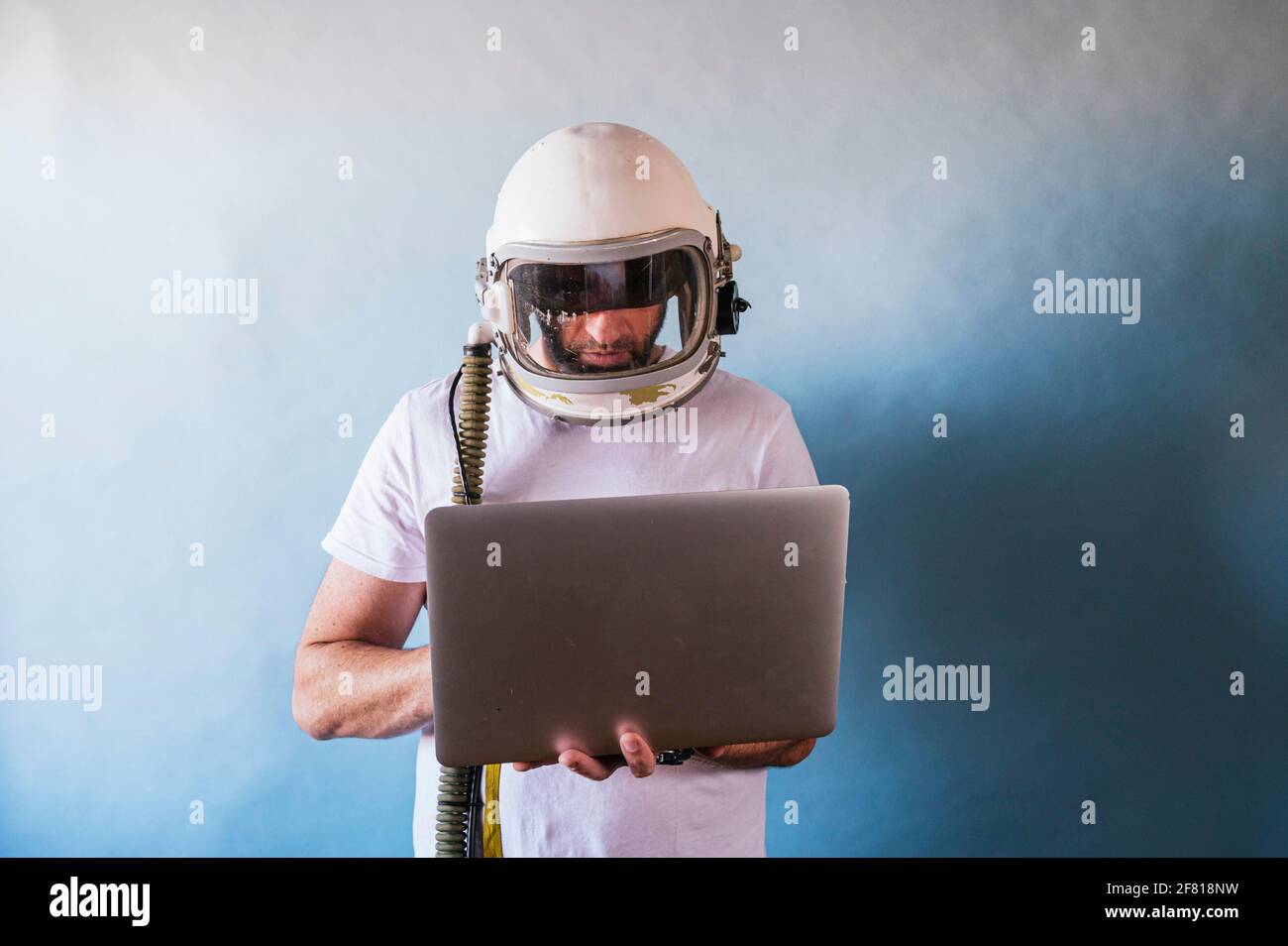 Man with astronaut helmet using laptop Stock Photo - Alamy