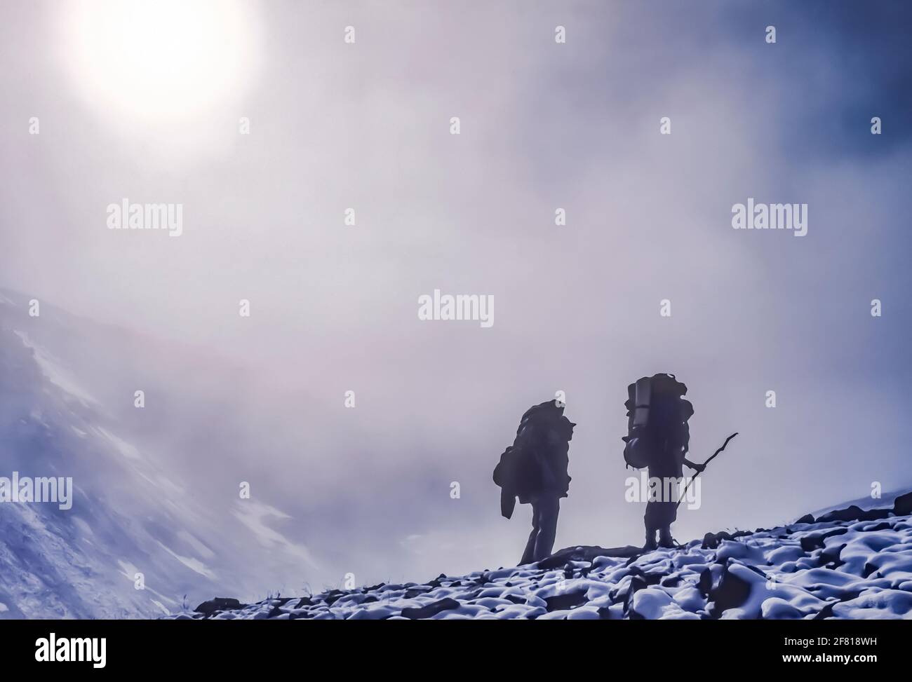 Backpacking up steep and snowy mountain slopes toward a pass in the ...