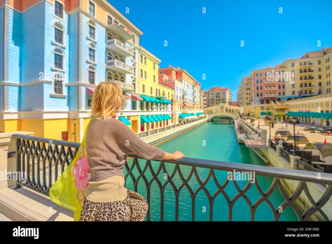 Blonde woman on balcony looking canals of Venice in Doha Qatar ...