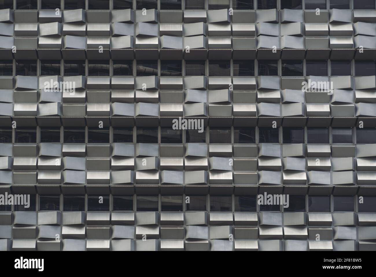 A grey facade of a modern office business high-rise building with rows ...