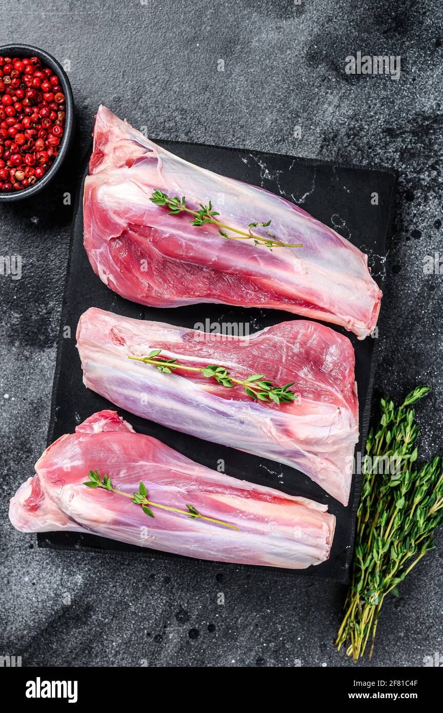Raw lamb shanks meat on a marble board. Black background. Top view ...