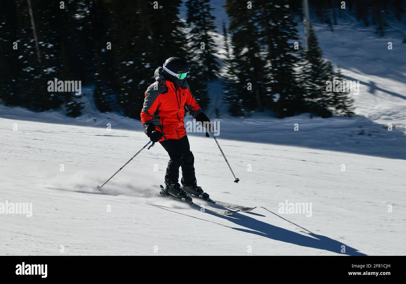 Skier going down the slopes on hi-speed at sunny day with fresh show at ...