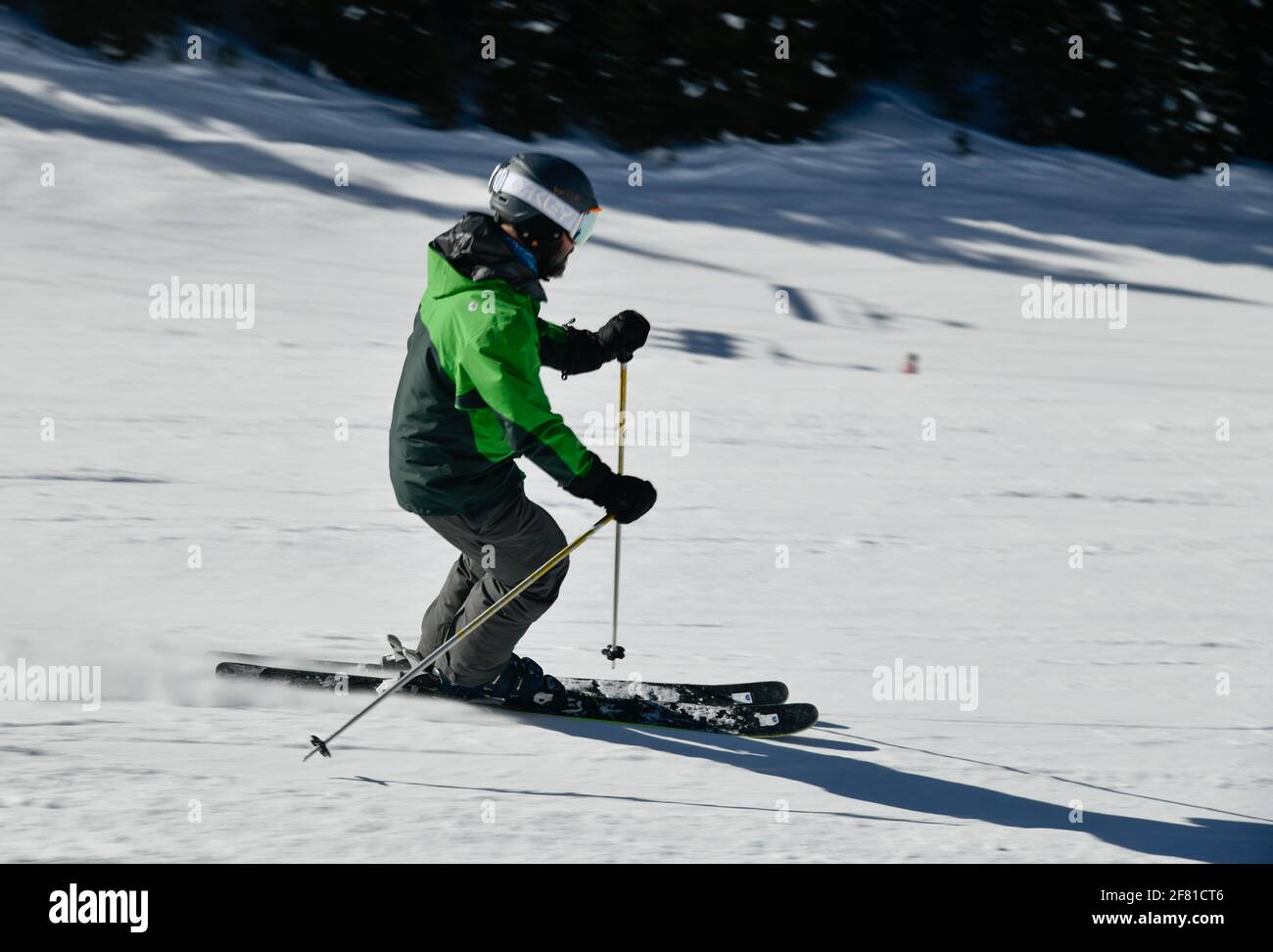 Skier going down the slopes on hi-speed at sunny day with fresh show at ...