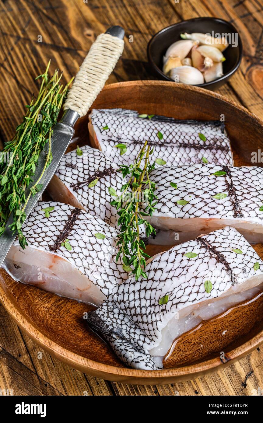 Cut Raw grenadier macrurus white fish without head in a wooden plate ...