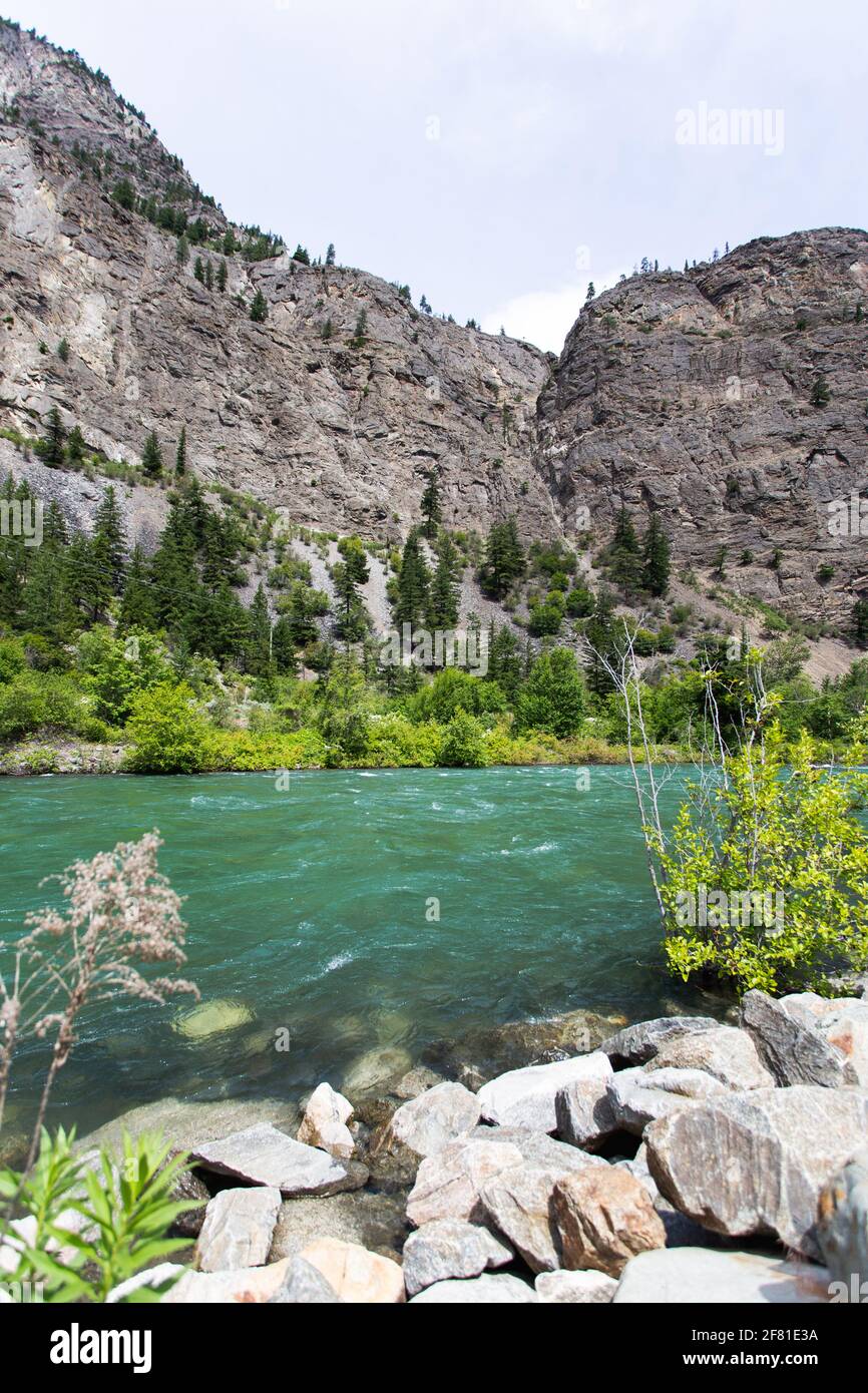 turquoise water river flowing next to a tall cliff in summer Stock ...