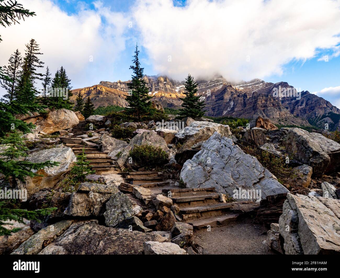 Stone stairs in the mountains looking up a peak with light from a ...