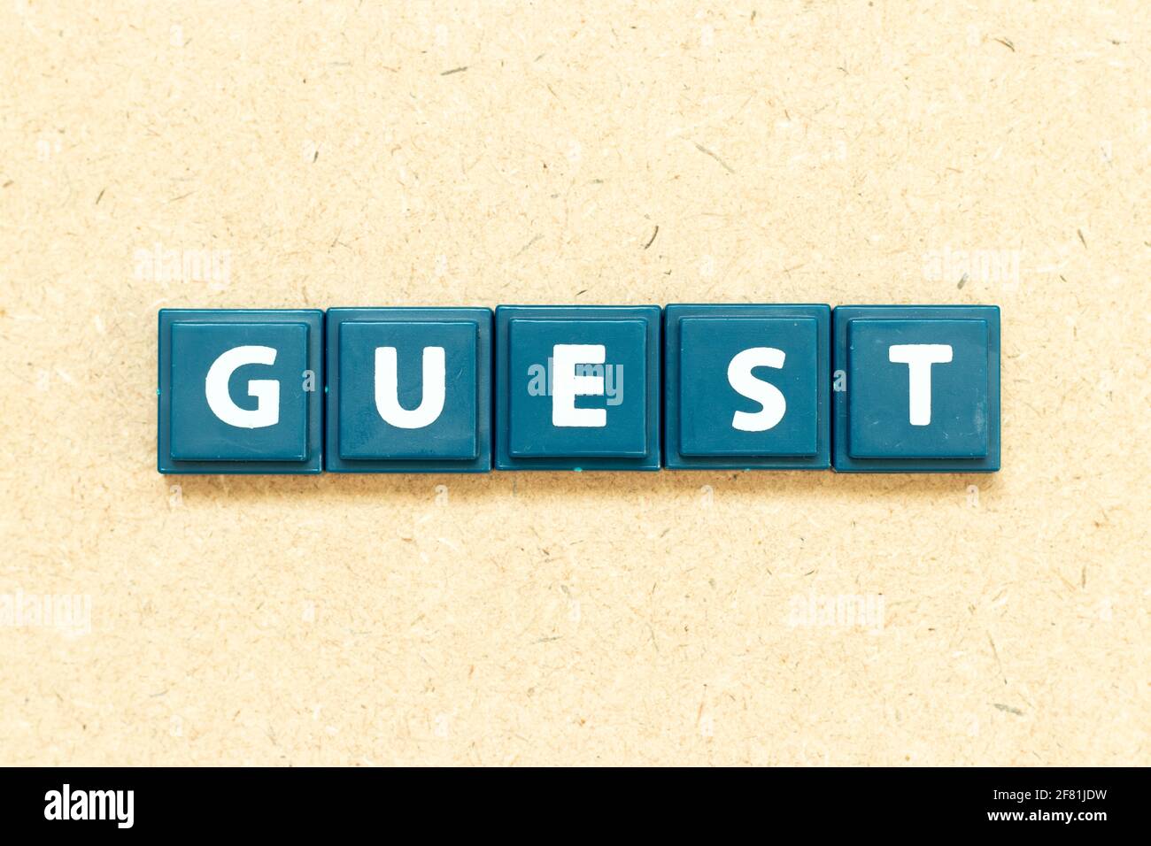 Tile alphabet letter in word guest on wood background Stock Photo - Alamy