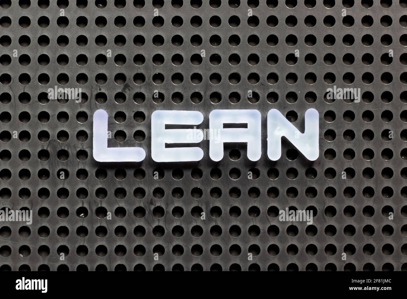 White color letter in word lean on black pegboard background Stock ...
