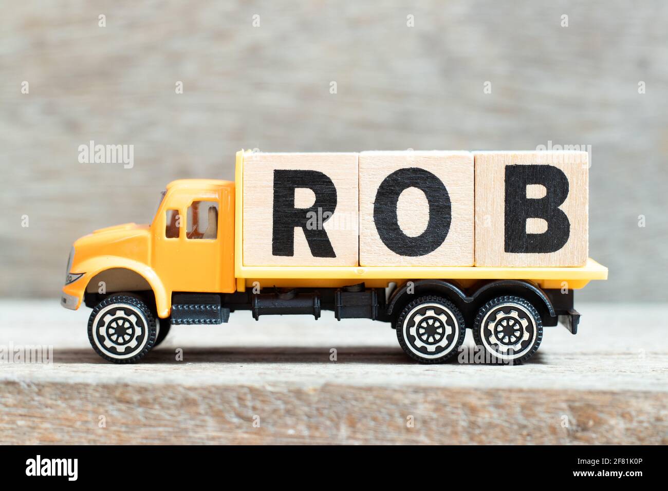 Toy truck hold alphabet letter block in word ROB (Abbreviation of ...