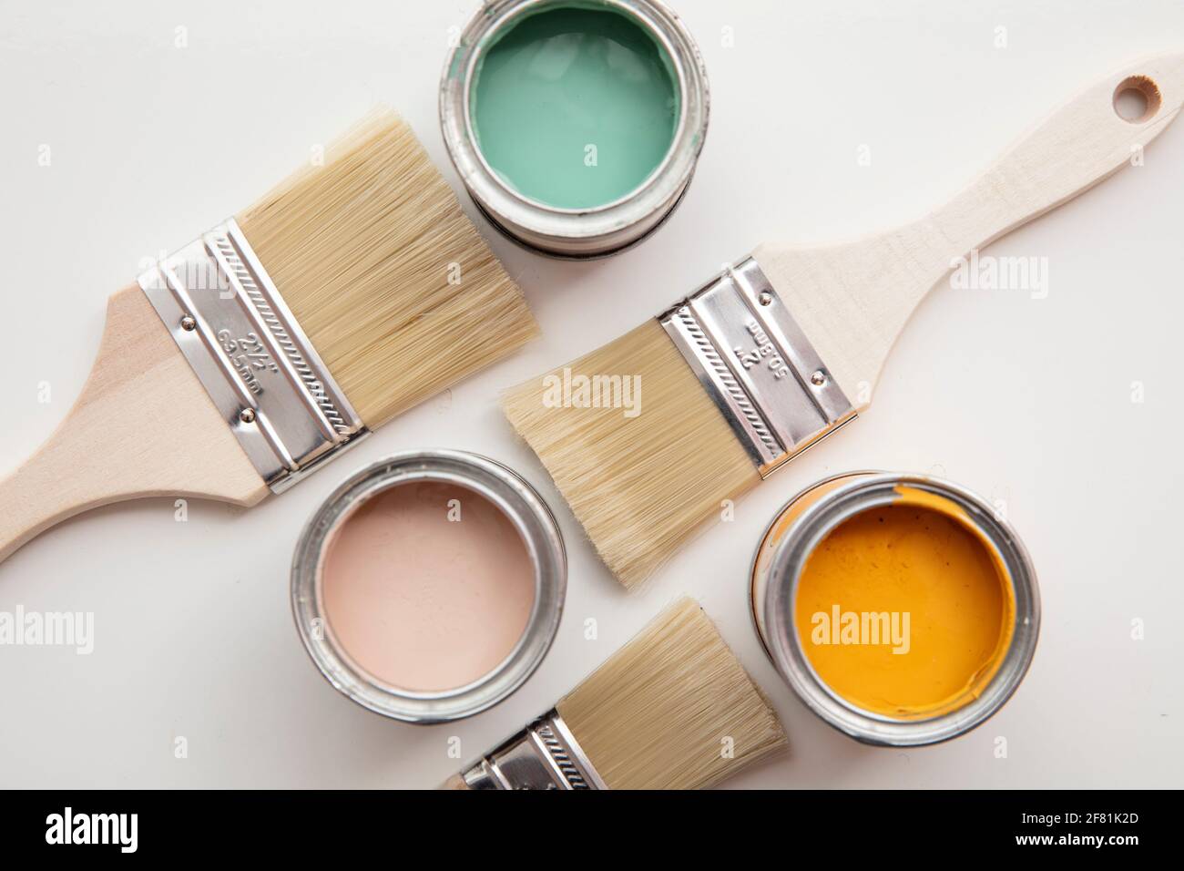 Overhead view of a DIY paint brush with colorful sample paint pots ...