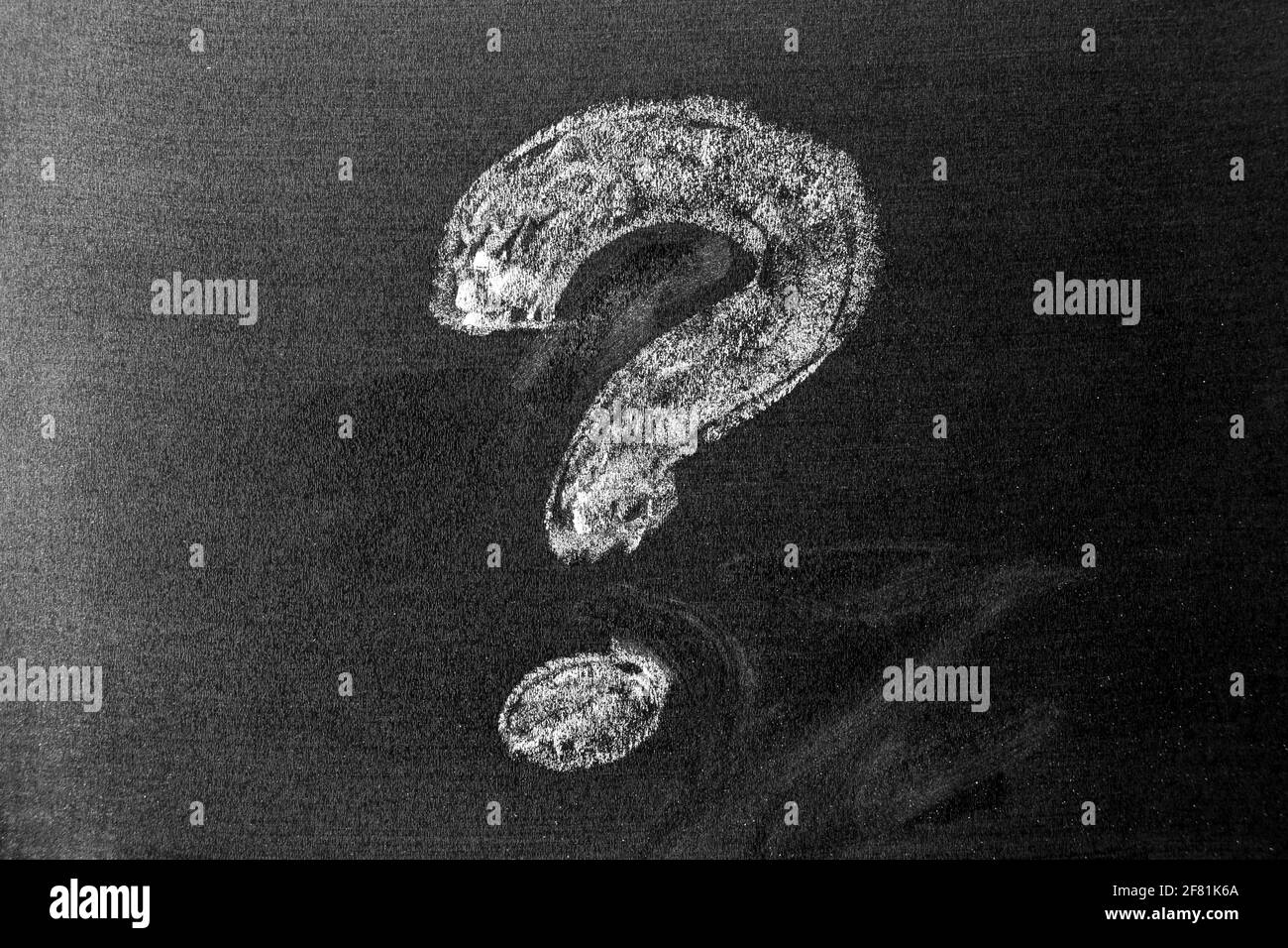 White color chalk hand drawing in question mark shape on blackboard or ...