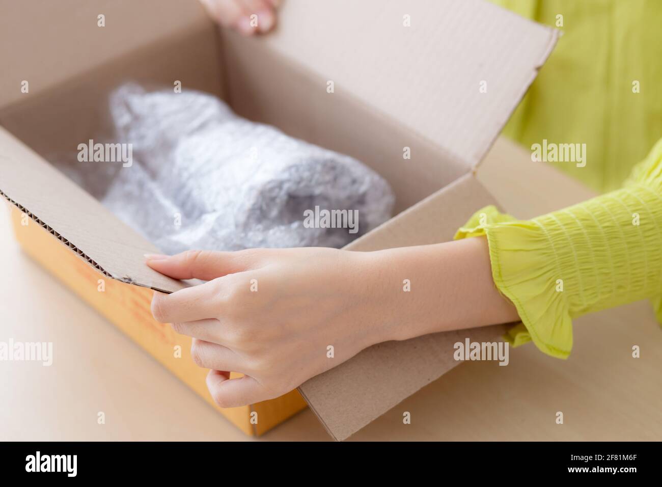Closeup hand of woman opening parcel box with check product at home ...