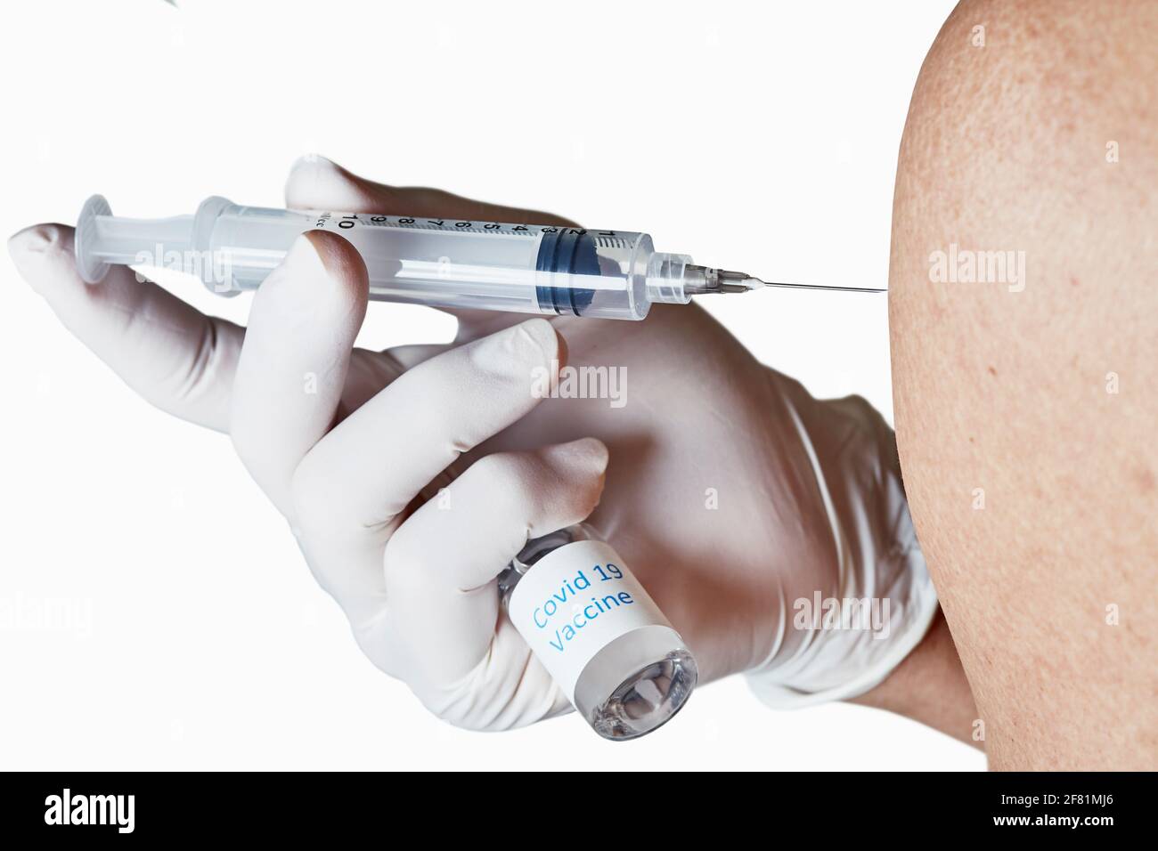 Gloved hand administering an injection in the arm while holding the ...