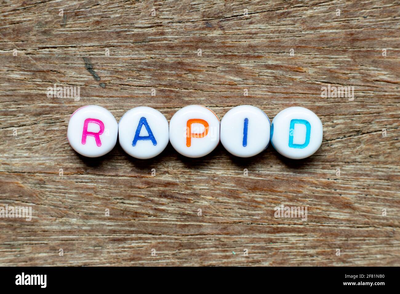 White bead with color letter in word rapid on wood background Stock ...