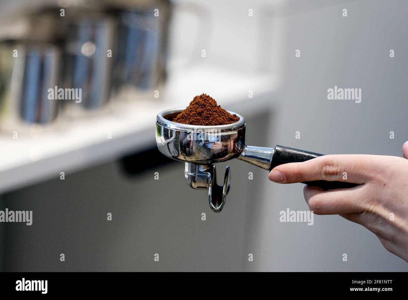 The hand of a young man is operating a professional coffee machine ...