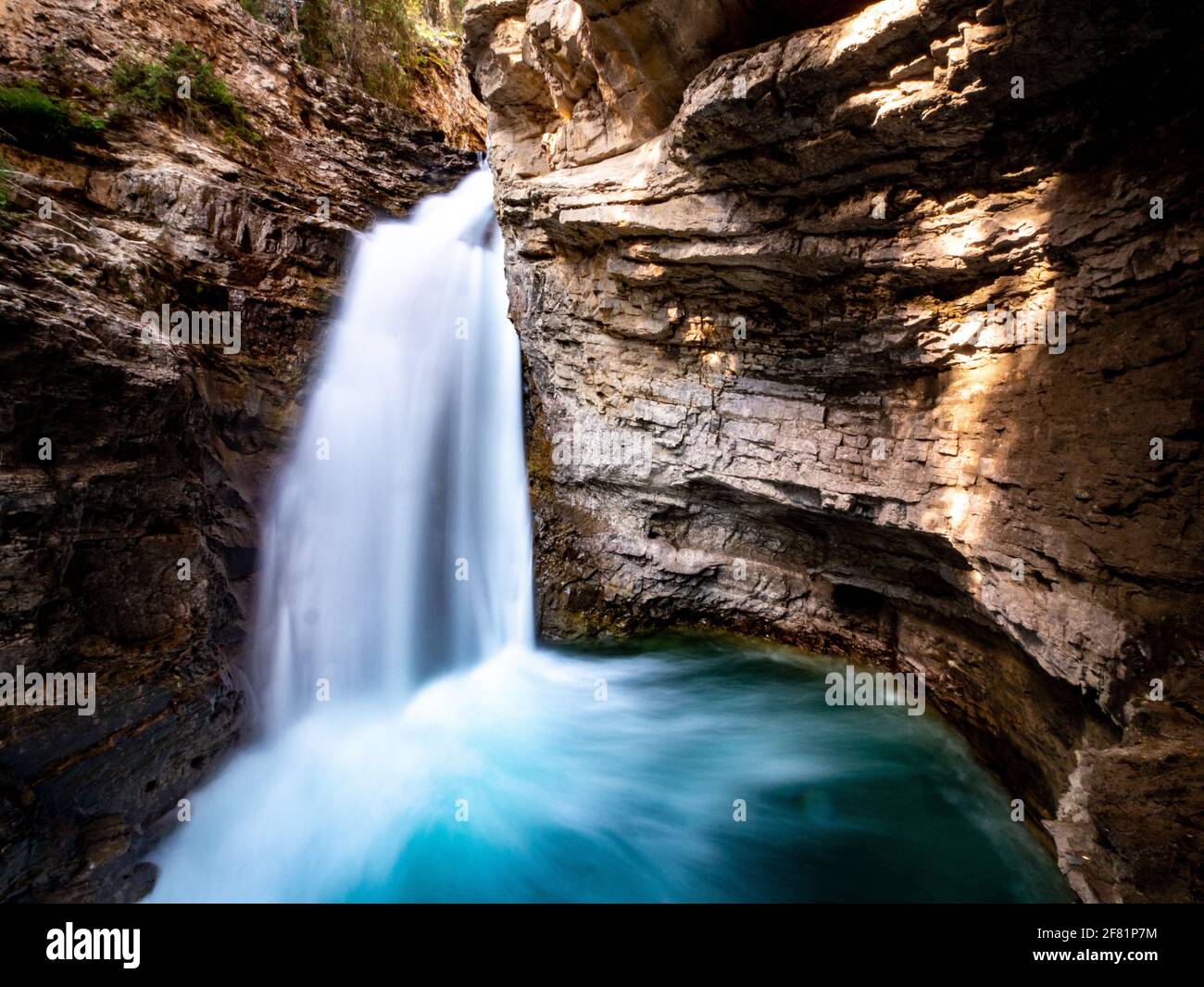 White waterfall in a cave with rock walls in summer with light Stock ...