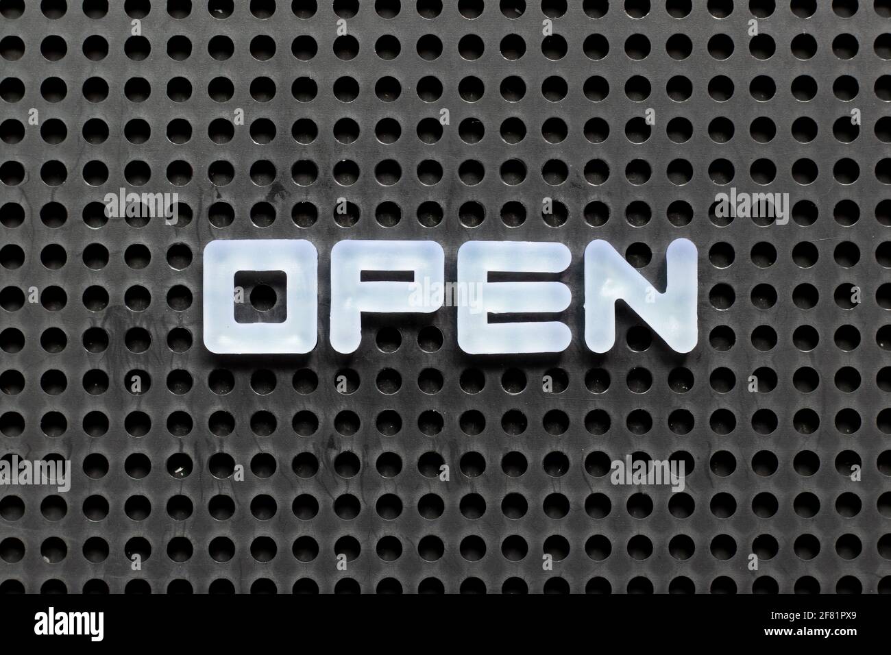 White color letter in word open on black pegboard background Stock ...