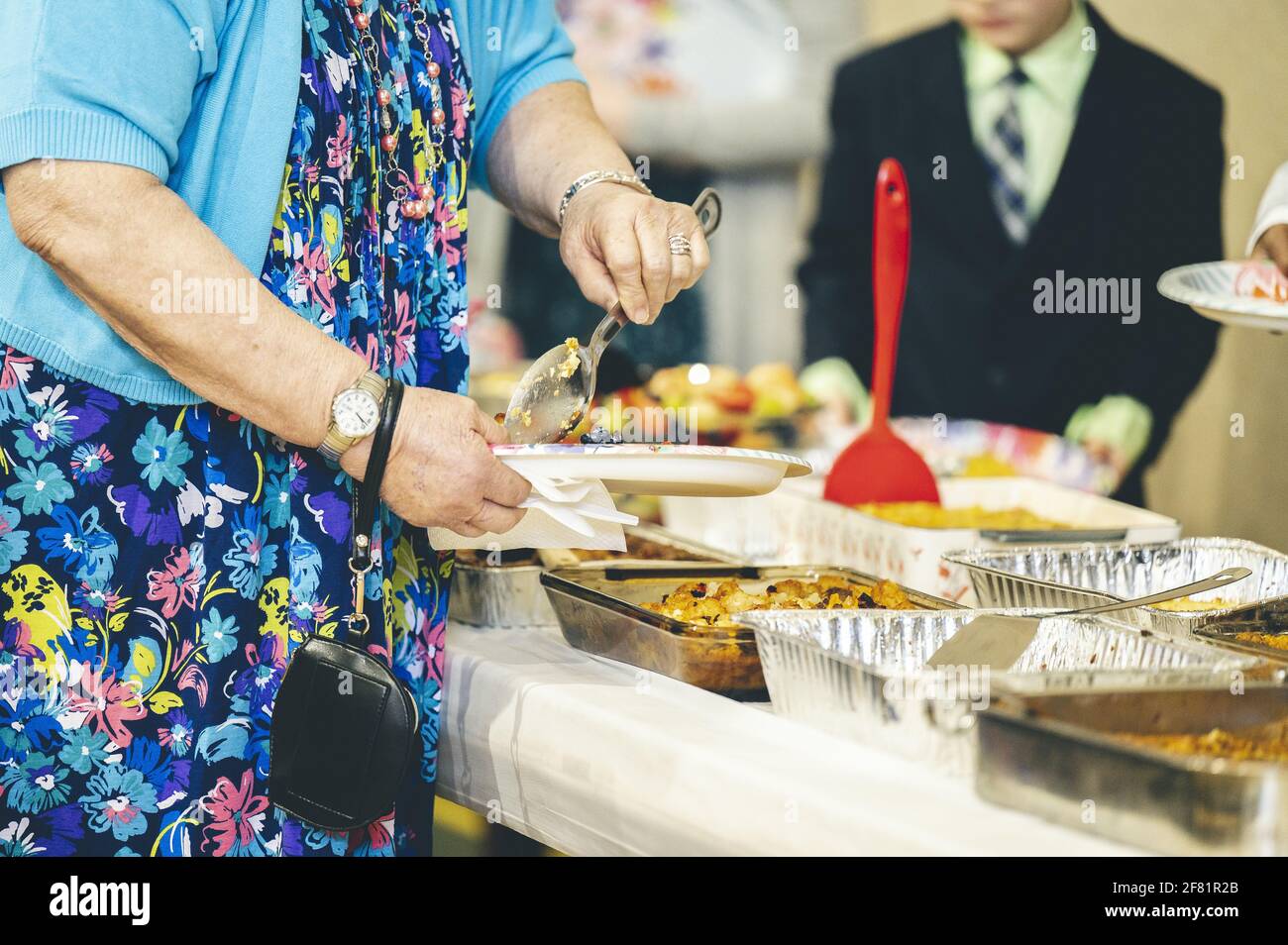 An aged female taking some food at a buffet Stock Photo - Alamy