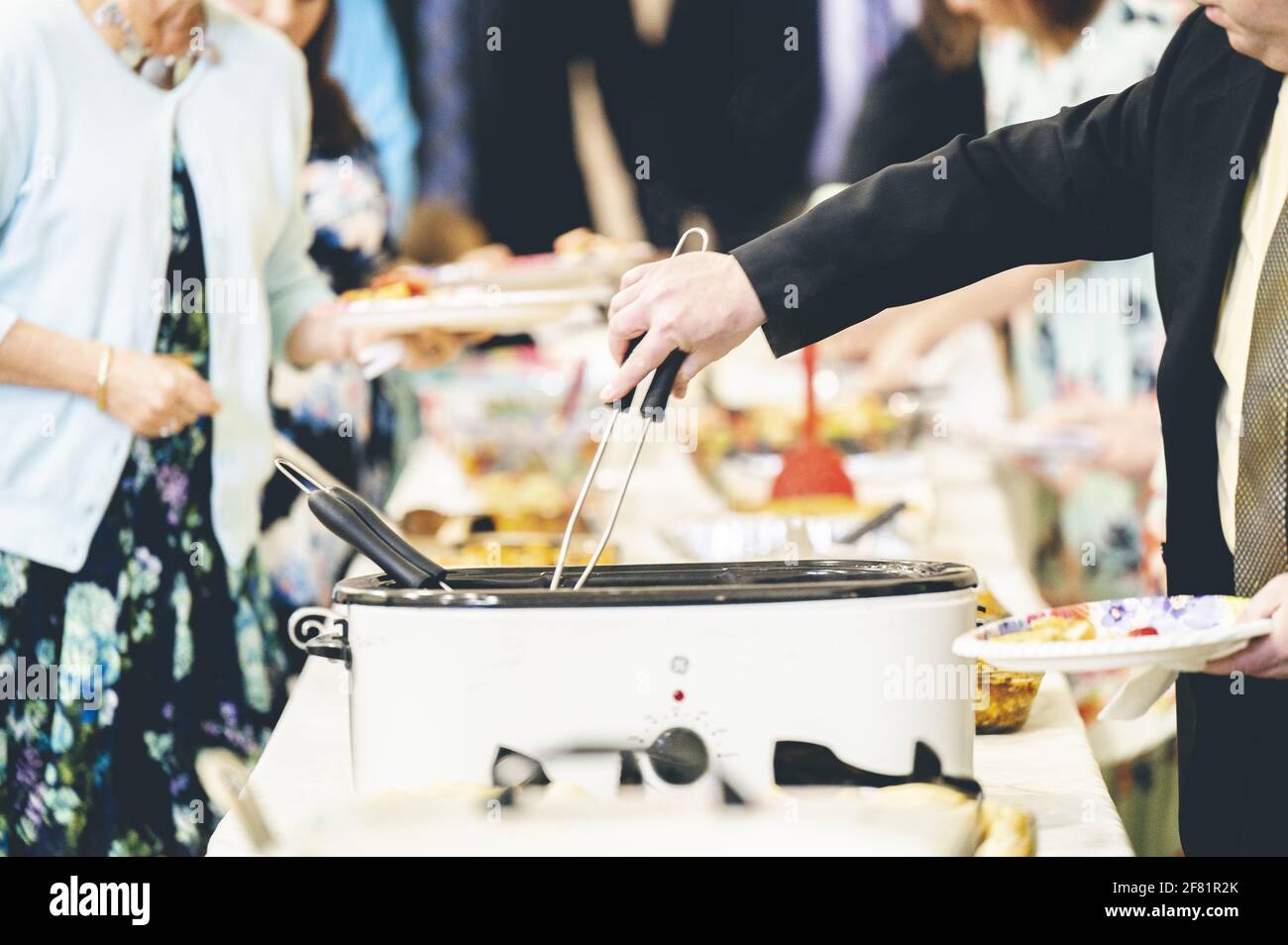 A male taking some food at a buffet Stock Photo - Alamy