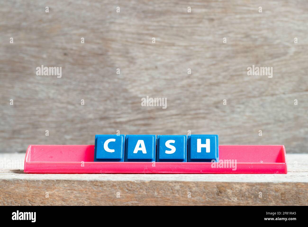 Tile letter on red rack in word cash on wood background Stock Photo - Alamy