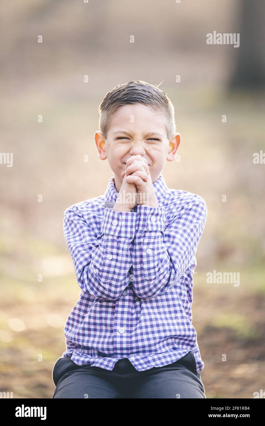 A vertical shot of a little Christian boy praying Stock Photo - Alamy