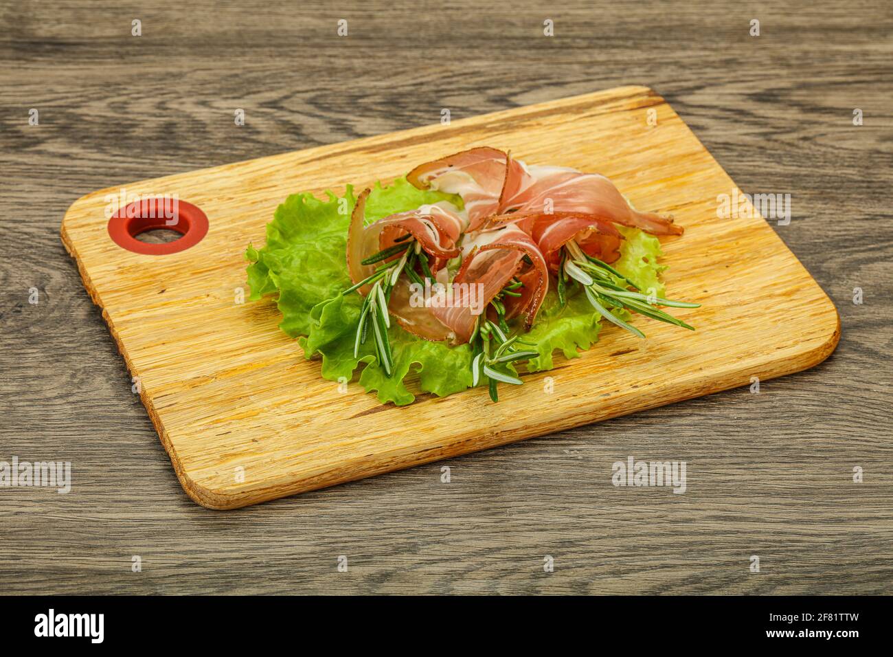 Sliced pork Jamon meat with rosemary Stock Photo - Alamy
