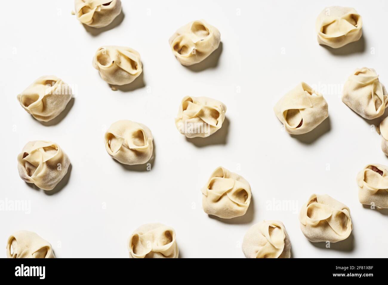 A top view of delicious homemade manti dumplings on a white surface ...