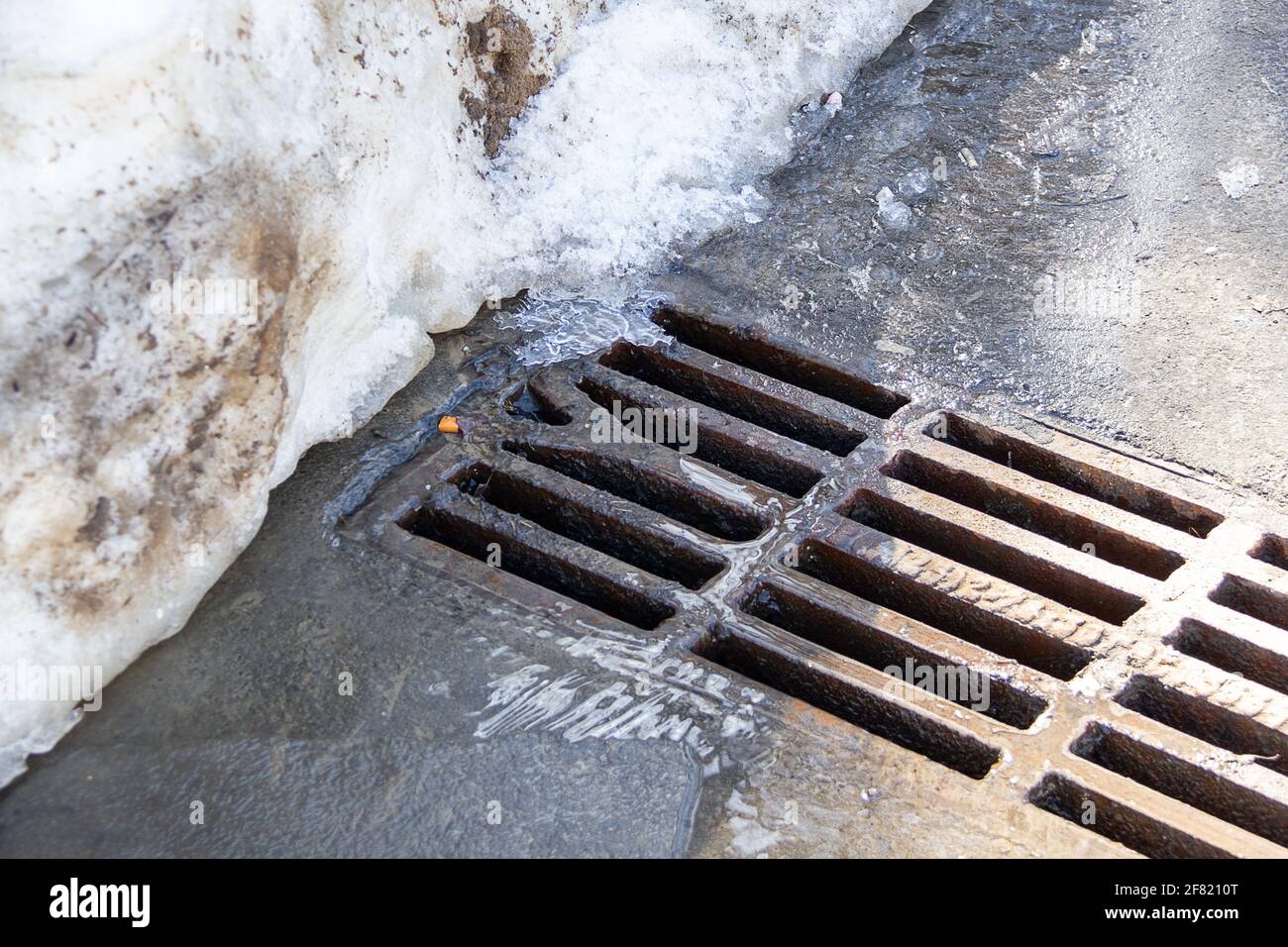 Water flows through the manhole cover, melting snow in the spring. View ...