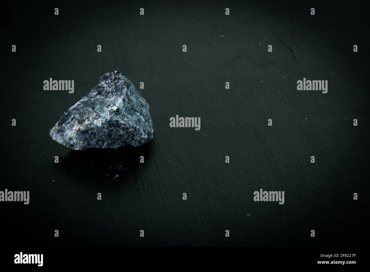 Granite. Natural mineral stone on a black background surrounded by moss ...