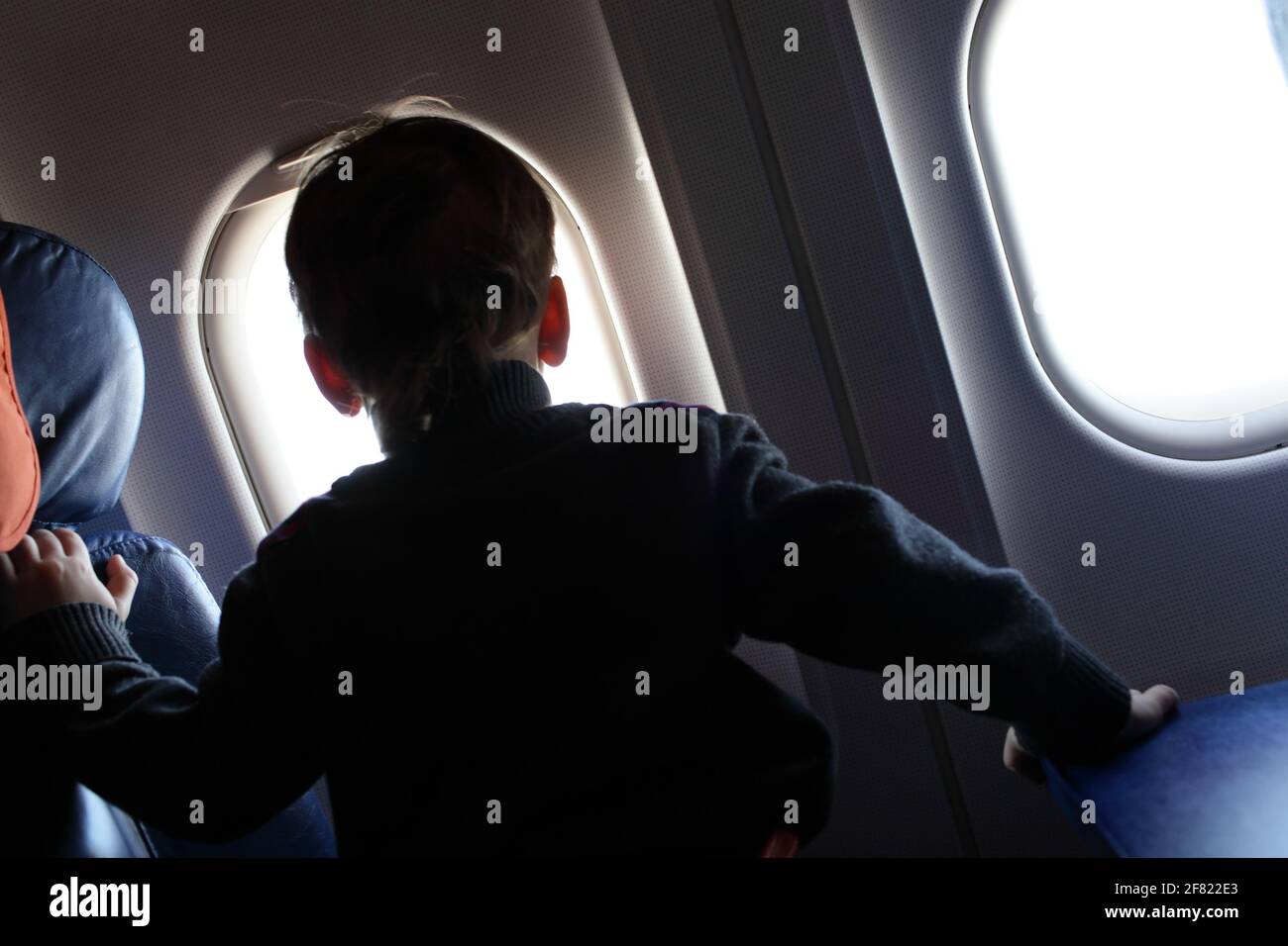 Child looking out the window of the aircraft Stock Photo - Alamy