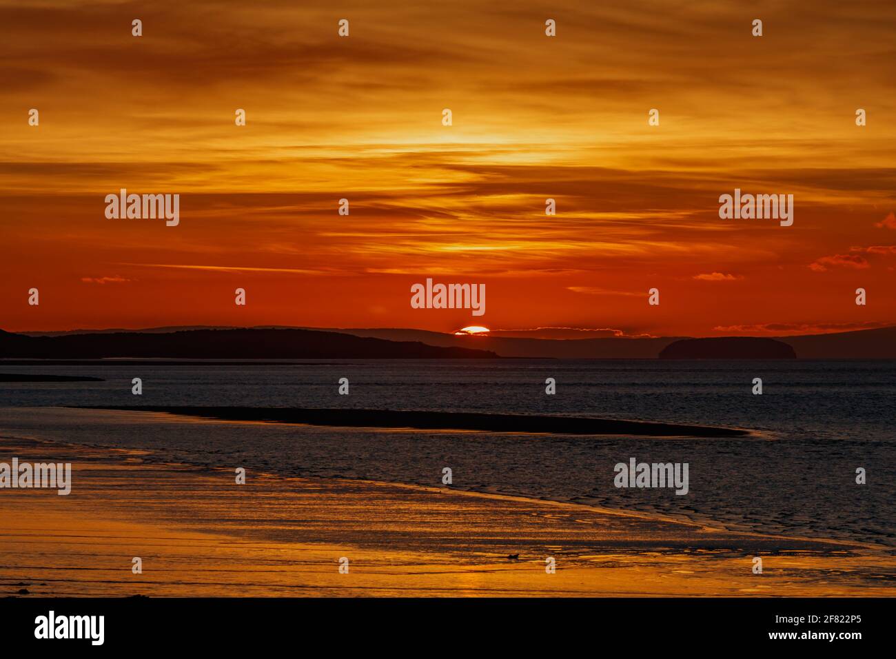 The sun setting over the horizon Stock Photo - Alamy