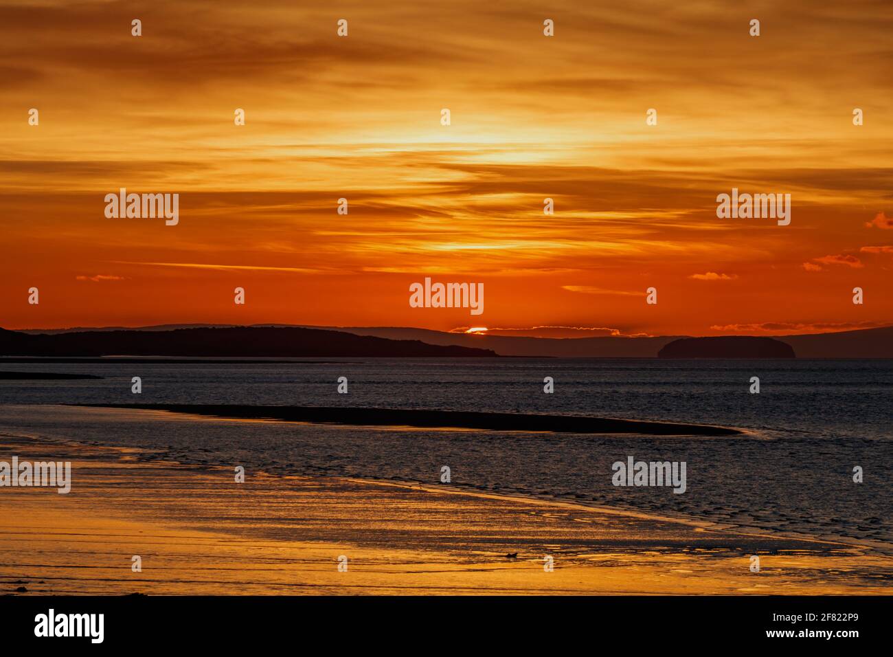 The sun setting over the horizon Stock Photo - Alamy