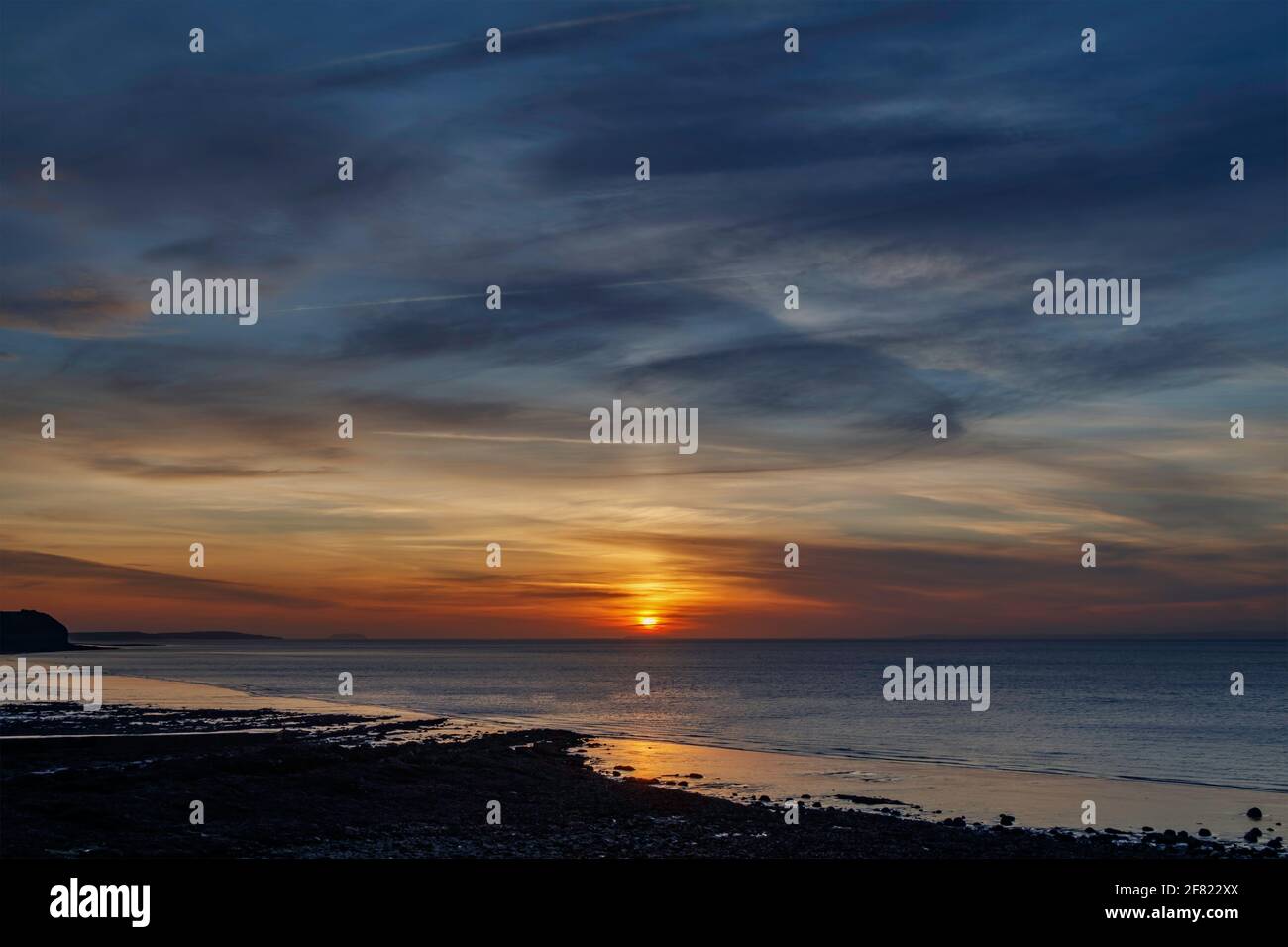 The sun setting over the horizon Stock Photo - Alamy