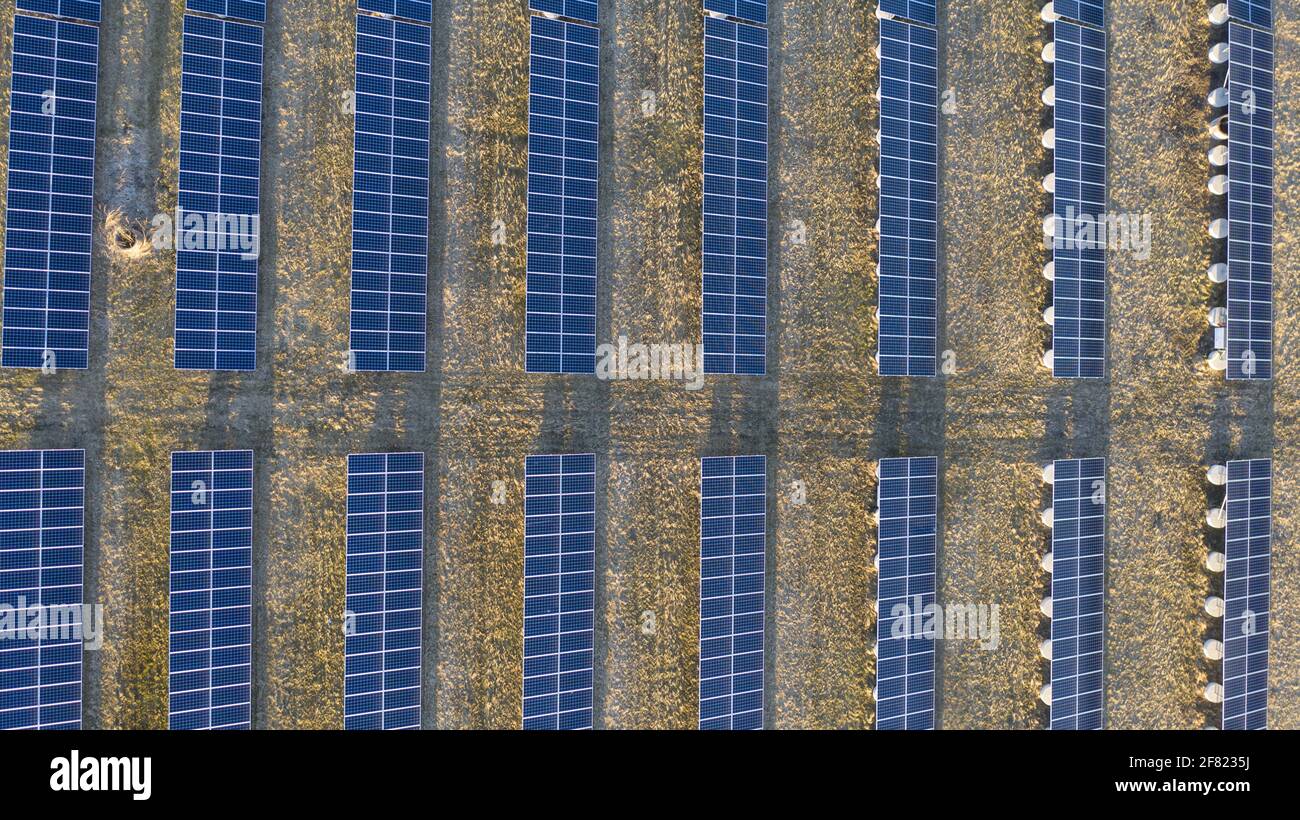 An aerial shot of solar panels in lines in the natural landscape Stock ...