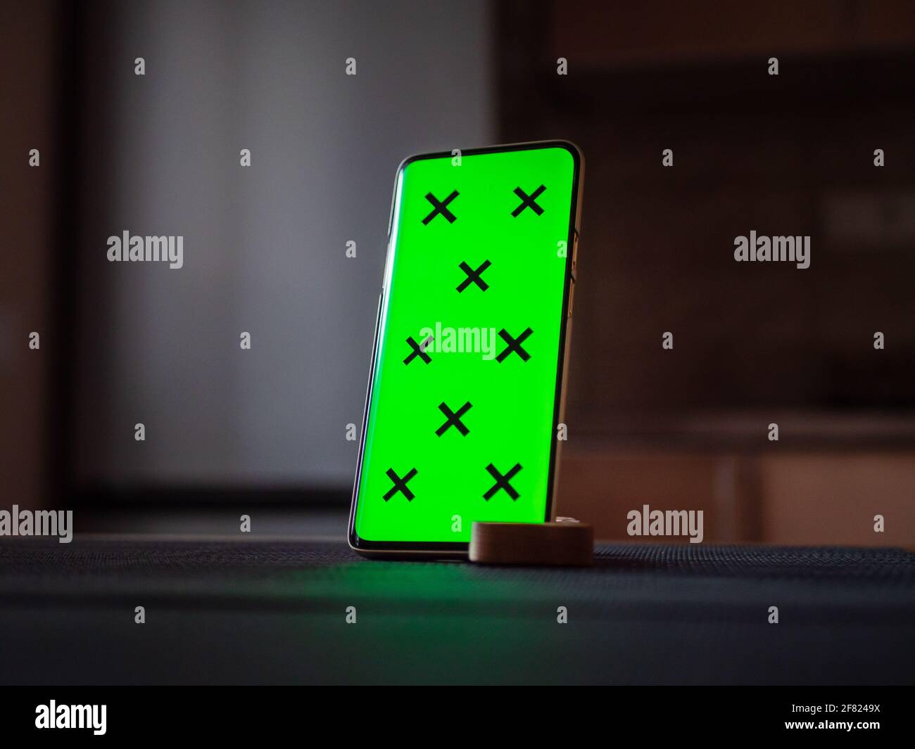 A smartphone with a green screen put vertically with a phone stand ...